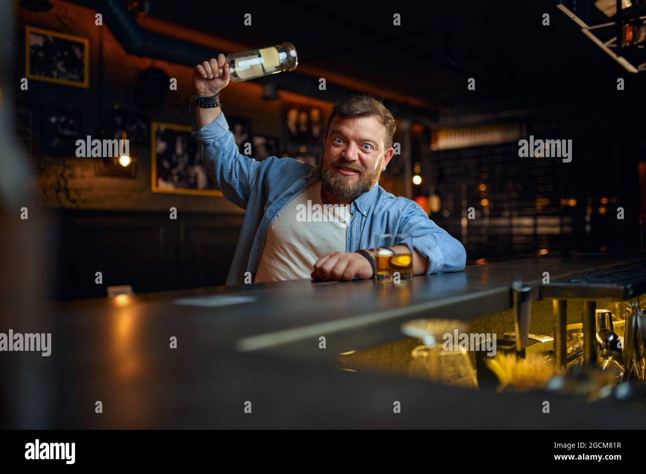 Mad drunk man swings the bottle at counter in bar Stock Photo - Alamy