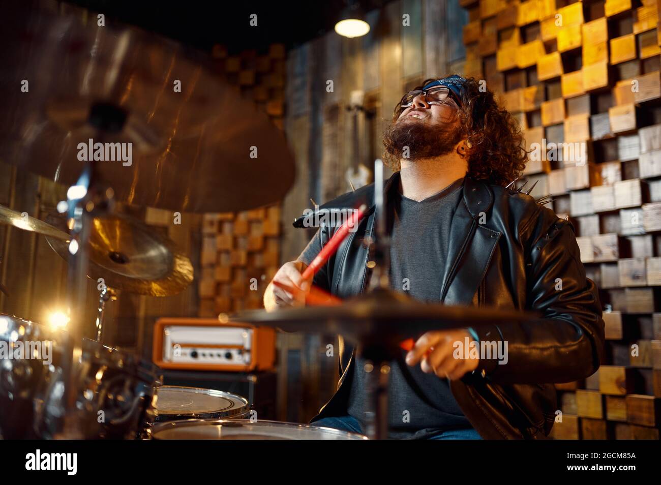 Brutal drummer behind the drum kit on stage Stock Photo - Alamy