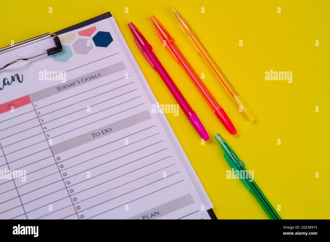 Set of pens and week calendar on yellow background Stock Photo - Alamy