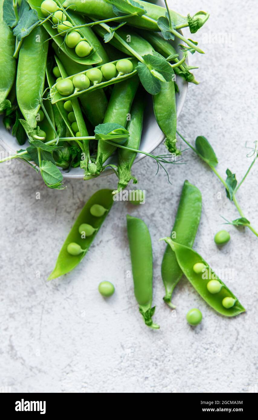 Fresh green peas pods and green peas with sprouts on concrete ...