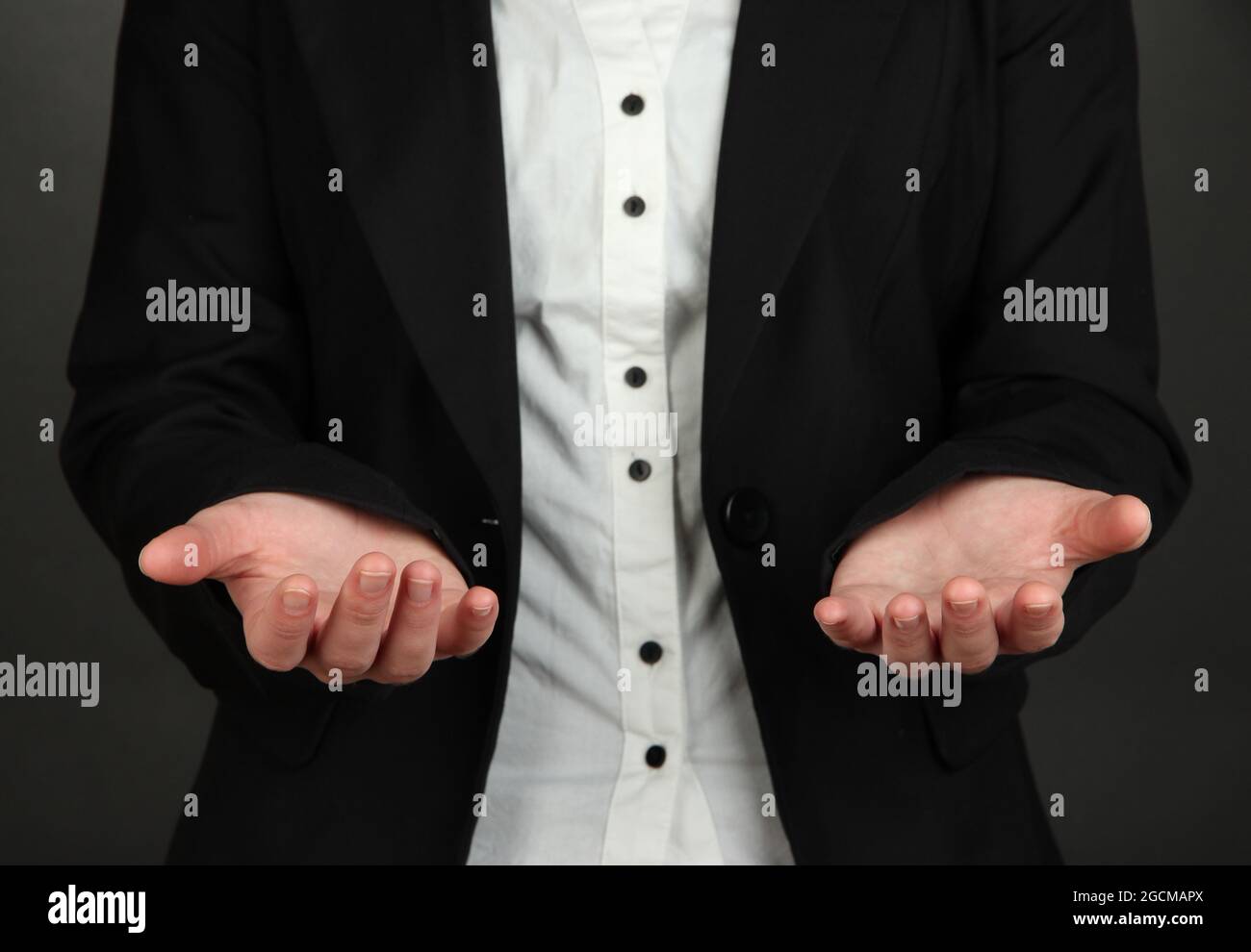 Female hands showing something on grey background Stock Photo - Alamy