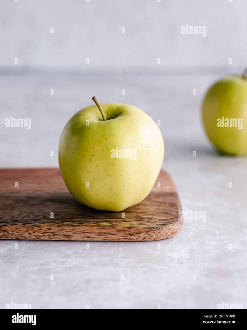 Golden delicious apple on a chopping board Stock Photo - Alamy