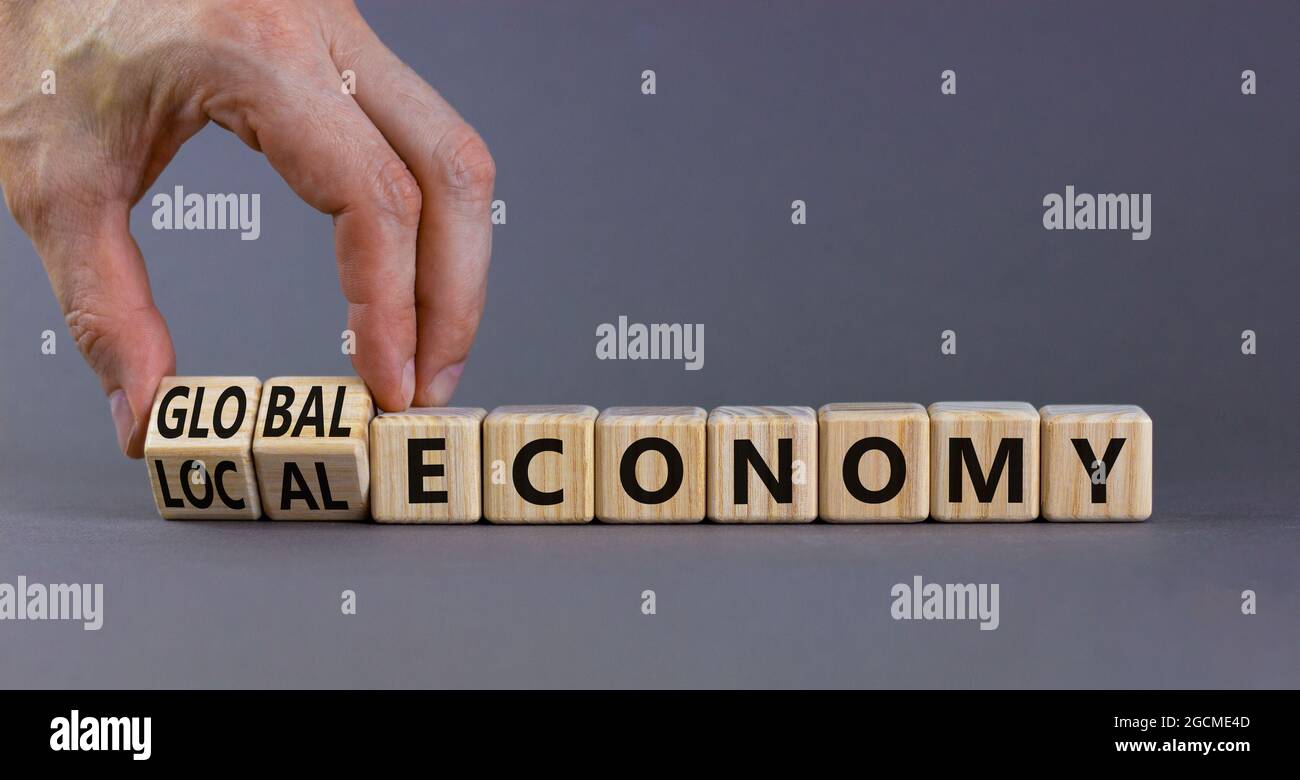 Local or global economy symbol. Businessman turns wooden cubes and ...