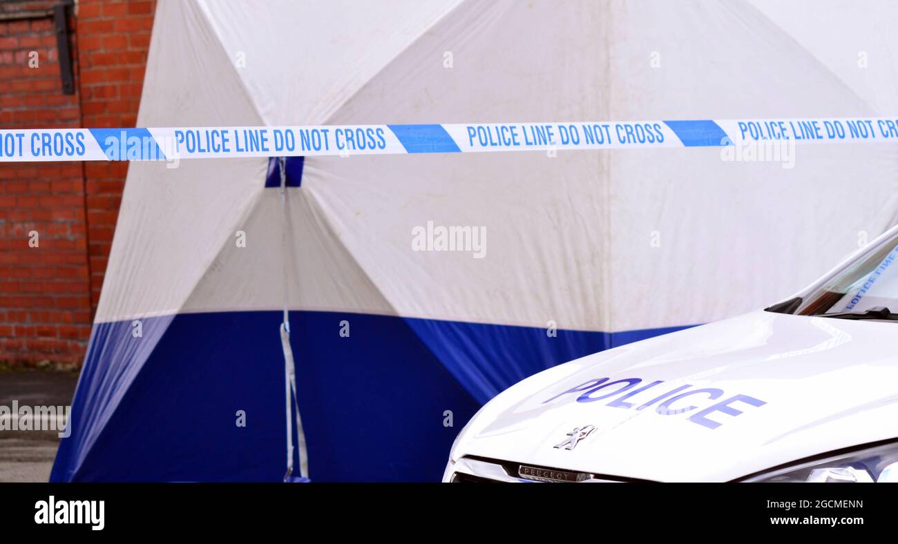 Police line or cordon: 'do not cross' and forensic tent and front of ...
