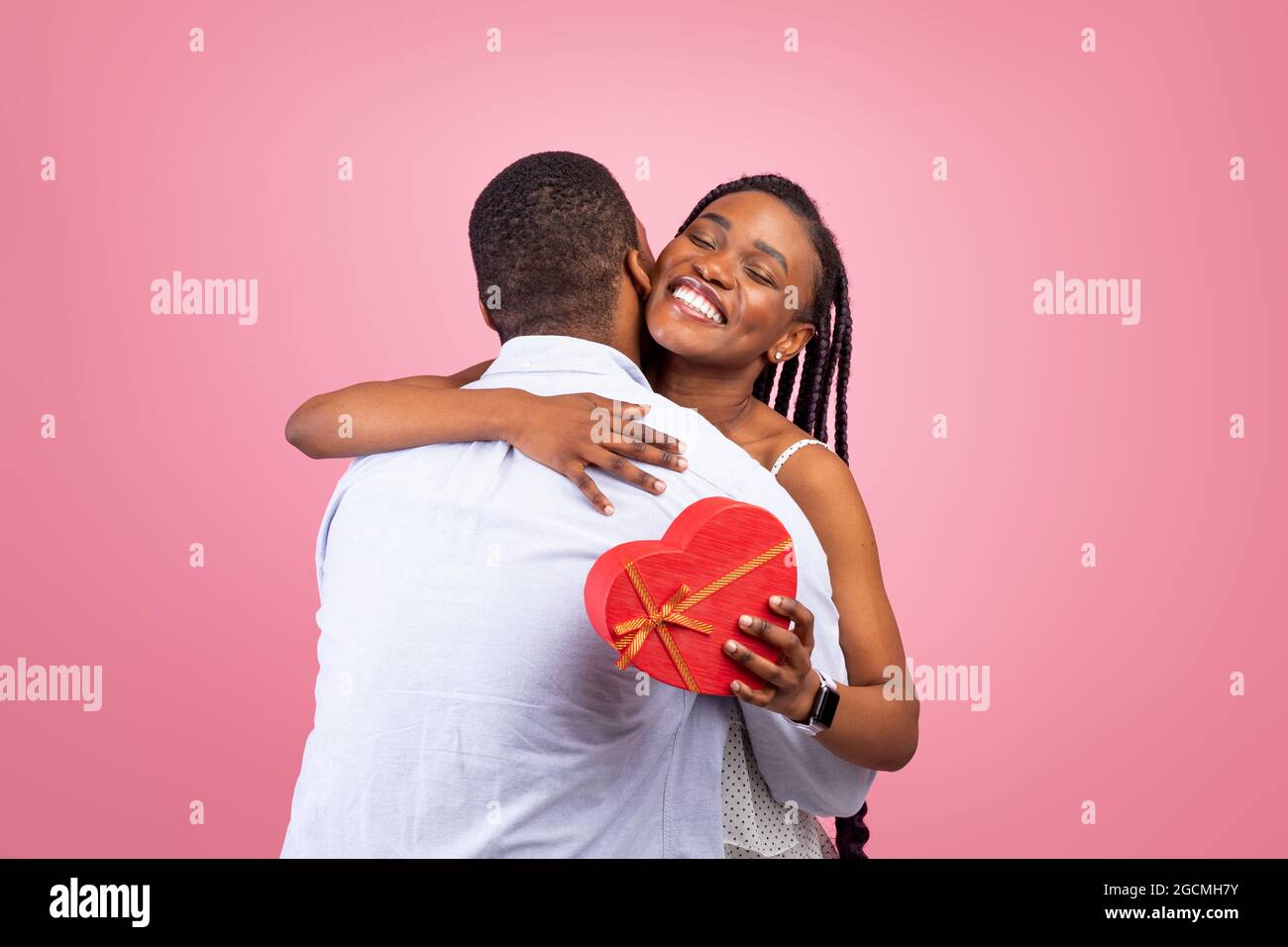 Happy black man making surprise for woman giving box Stock Photo - Alamy