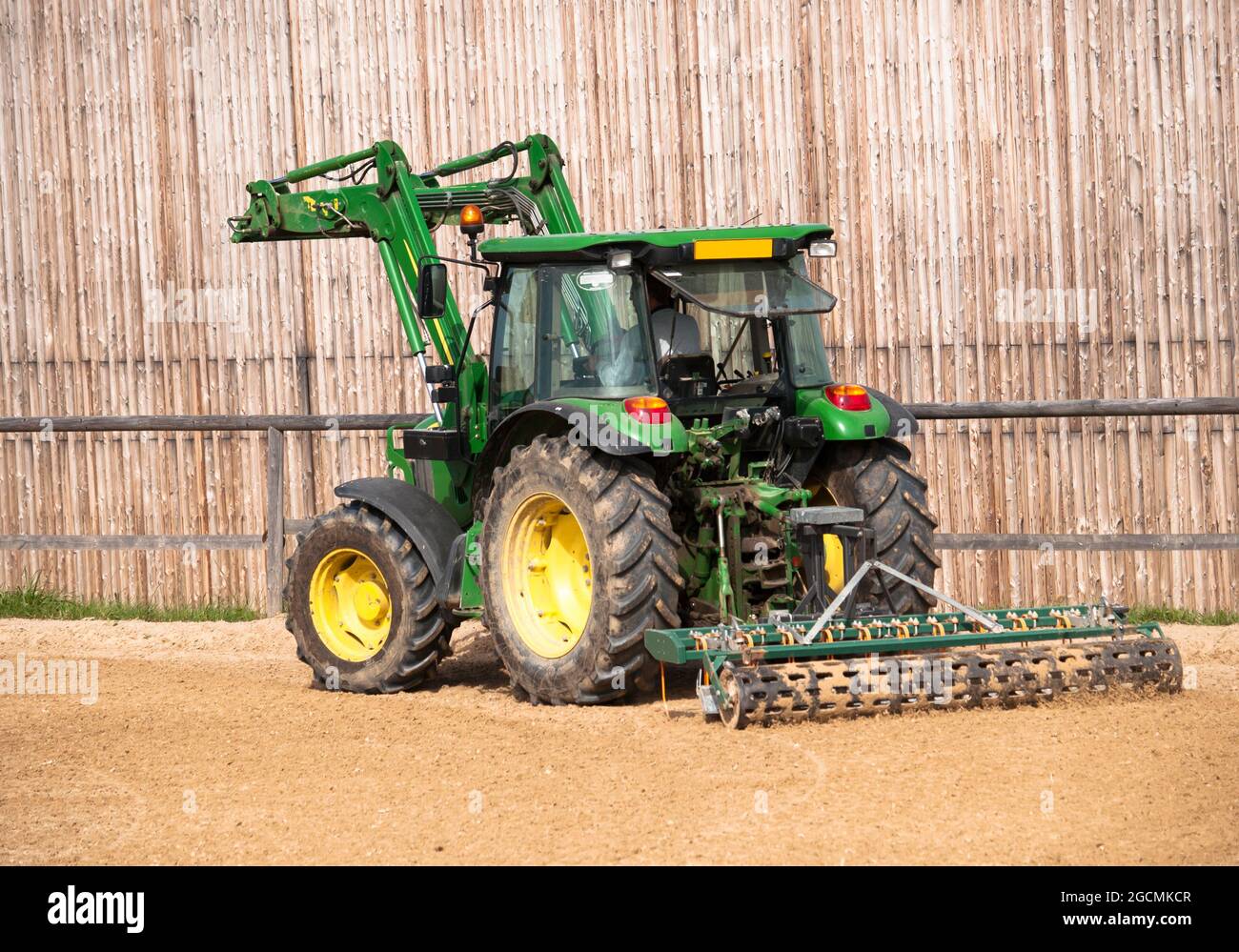 Tractor preparing surface in riding arena Stock Photo - Alamy