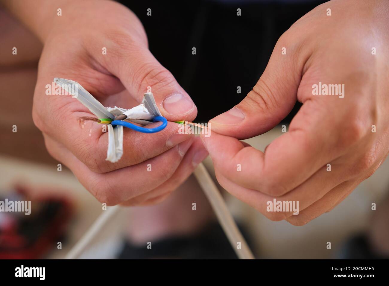 Young man hands repairing or splicing wires Stock Photo - Alamy