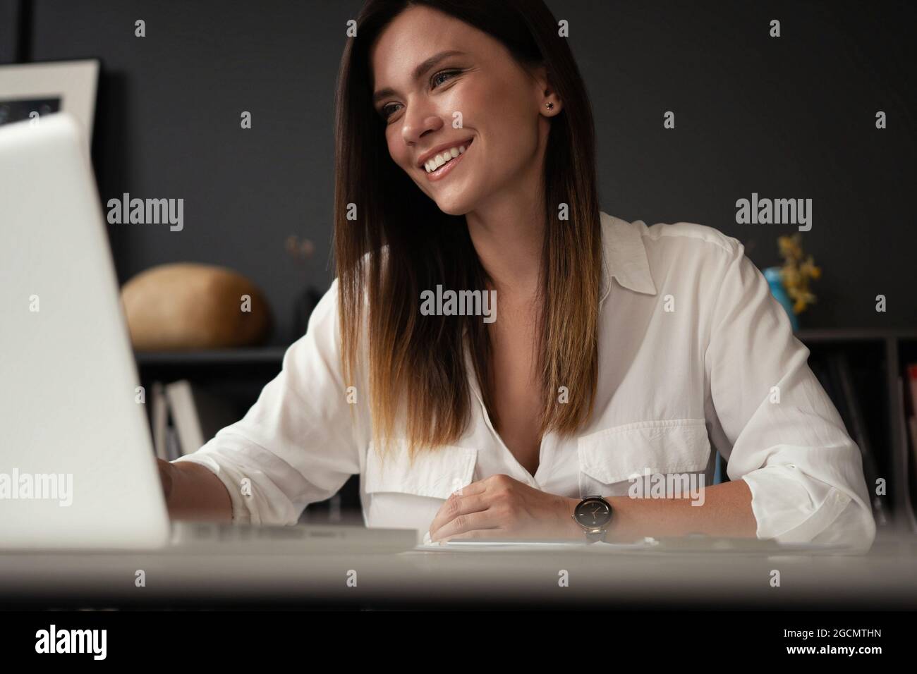 Beautiful Female Data Analyst sitting at the Table Works on a Laptop ...