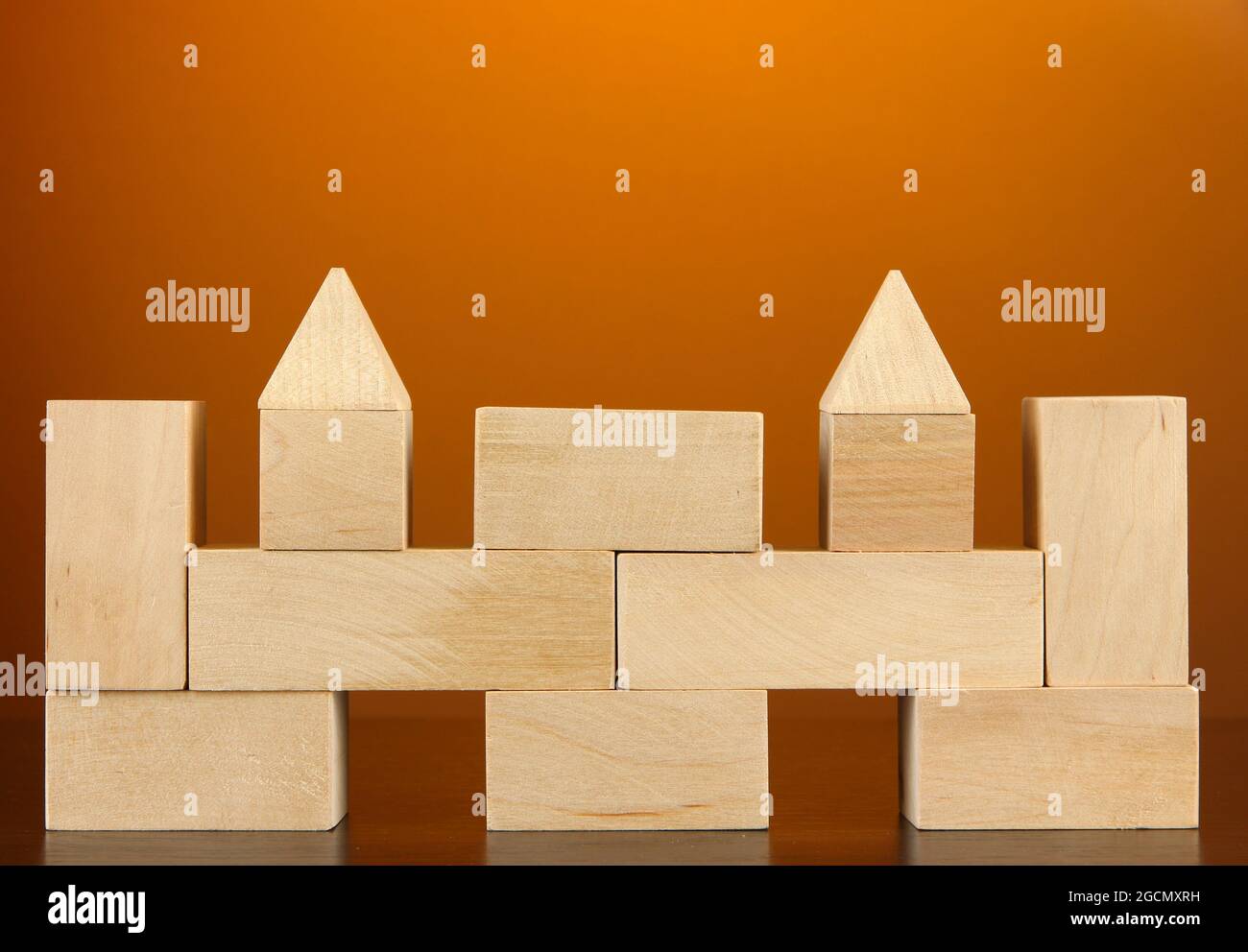 Wooden toy blocks table on yellow background Stock Photo - Alamy