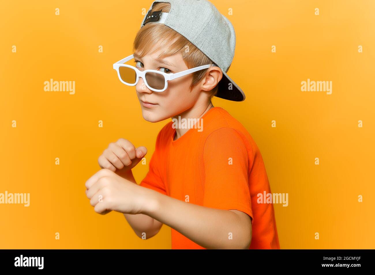 a child in glasses for watching movies clenched his fists and looks ...