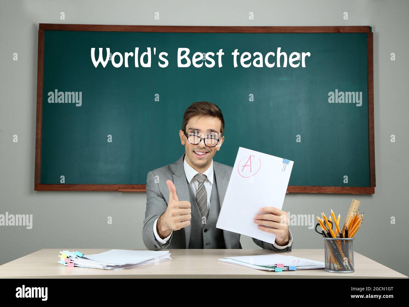 Young teacher sitting in school classroom Stock Photo - Alamy