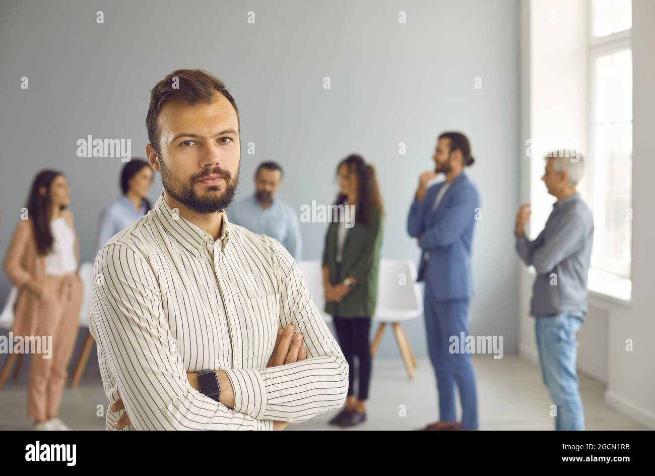 Portrait of a serious young professional businessman in the office on ...
