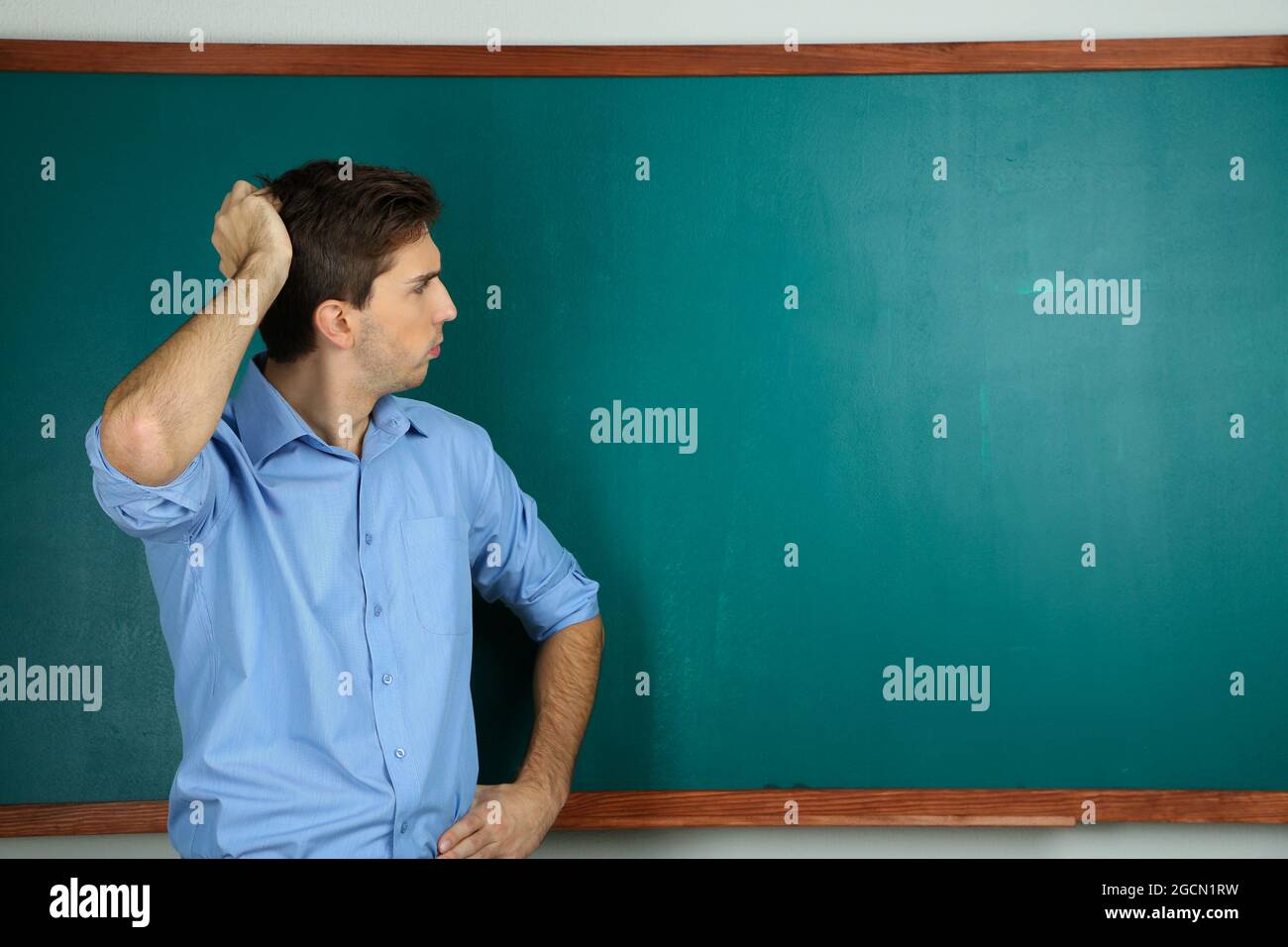 Young teacher near chalkboard in school classroom Stock Photo - Alamy
