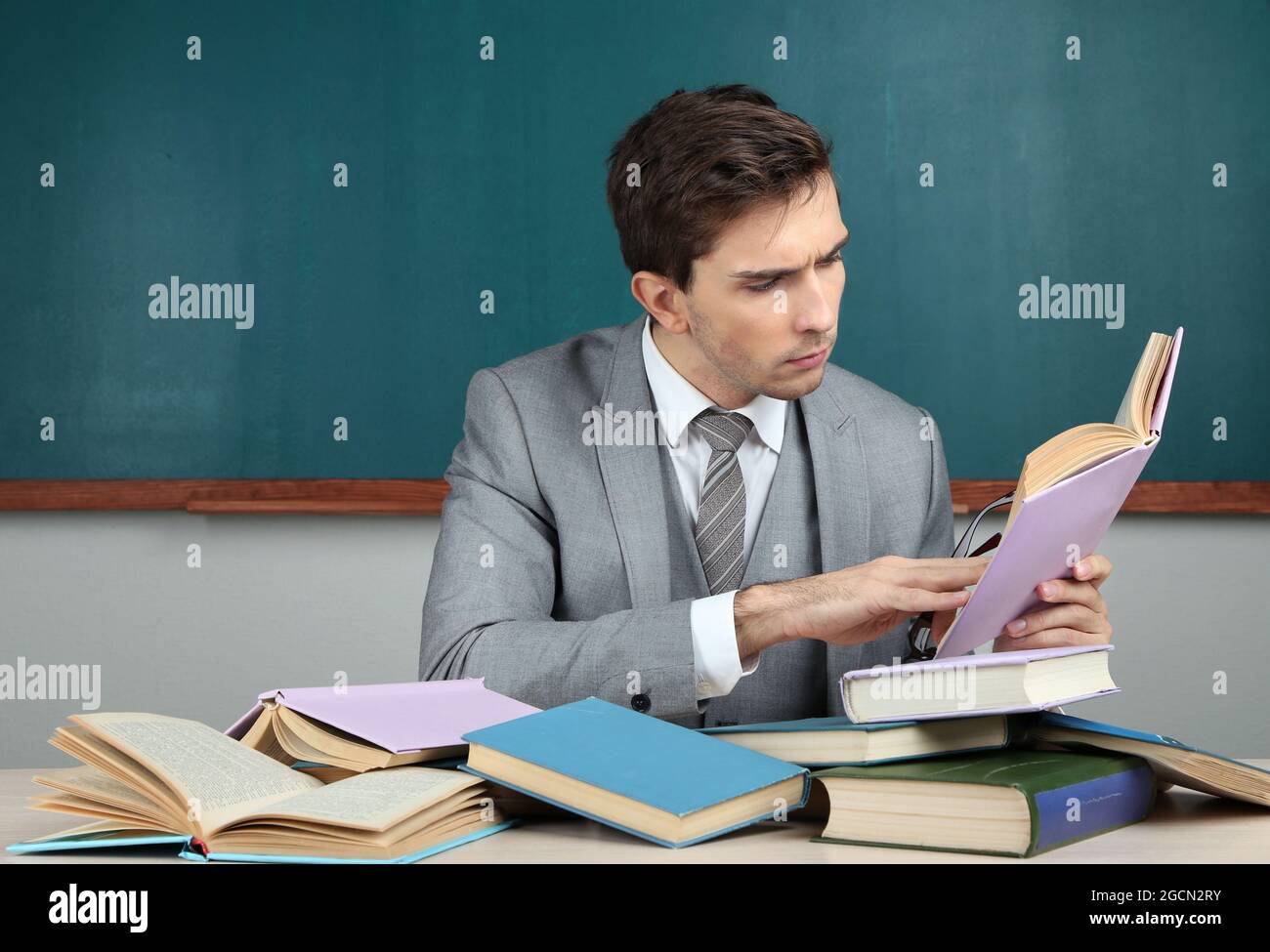 Young teacher sitting in school classroom Stock Photo - Alamy