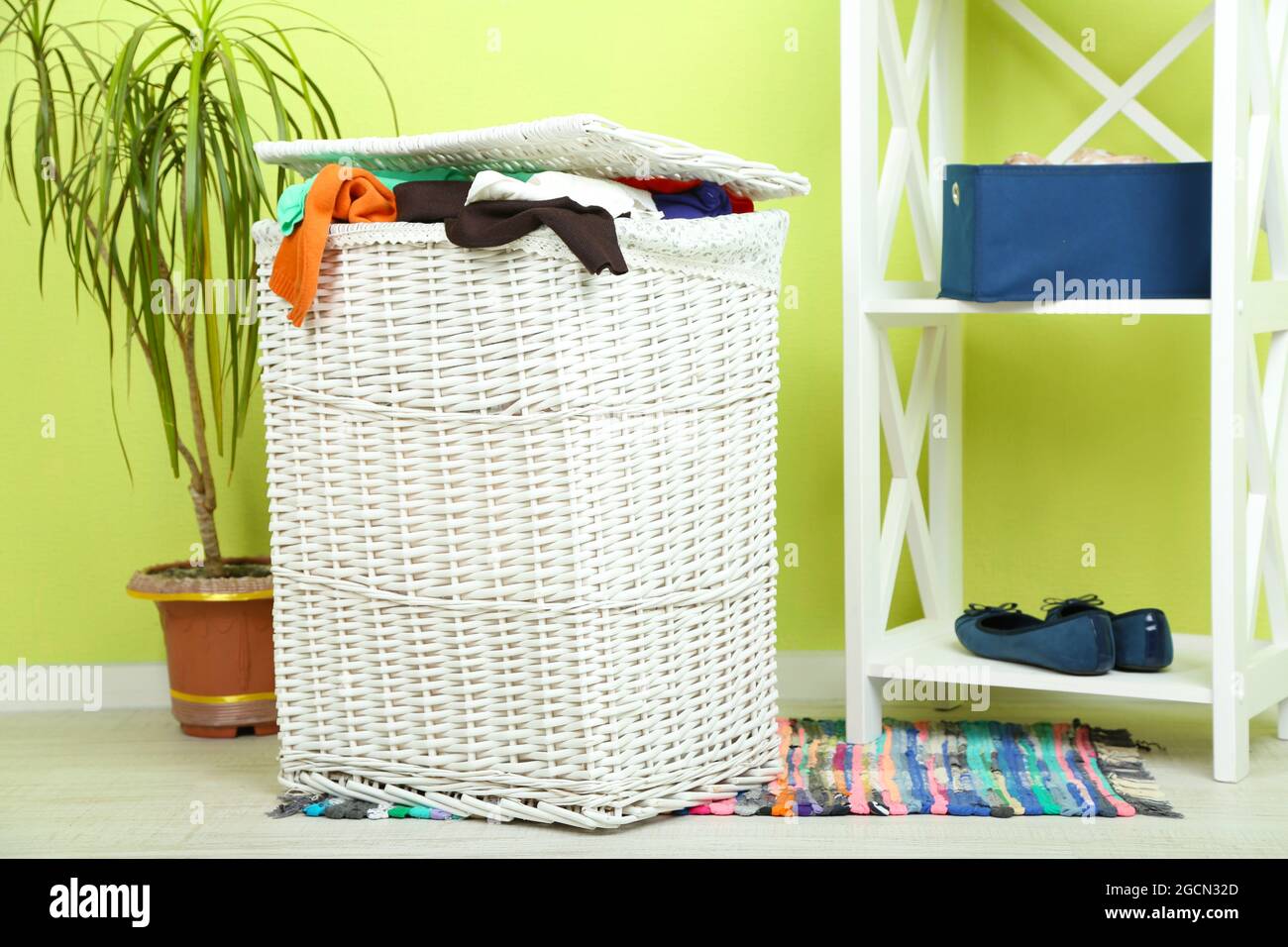 Full laundry basket on wooden floor on home interior background Stock ...
