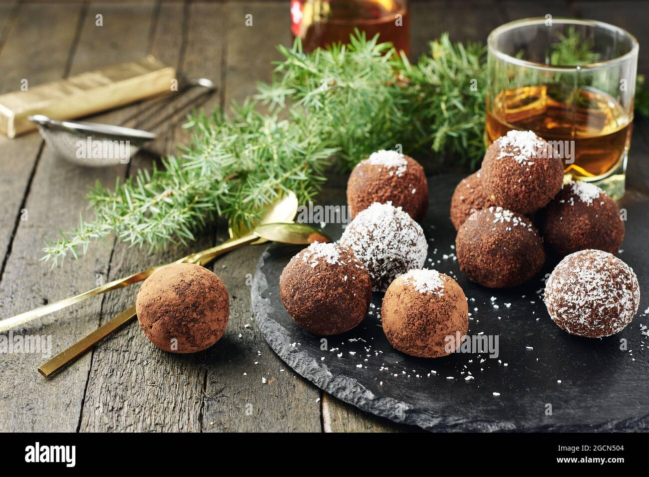 Chocolate rum balls with coconut flakes, sweet candies on a dark ...