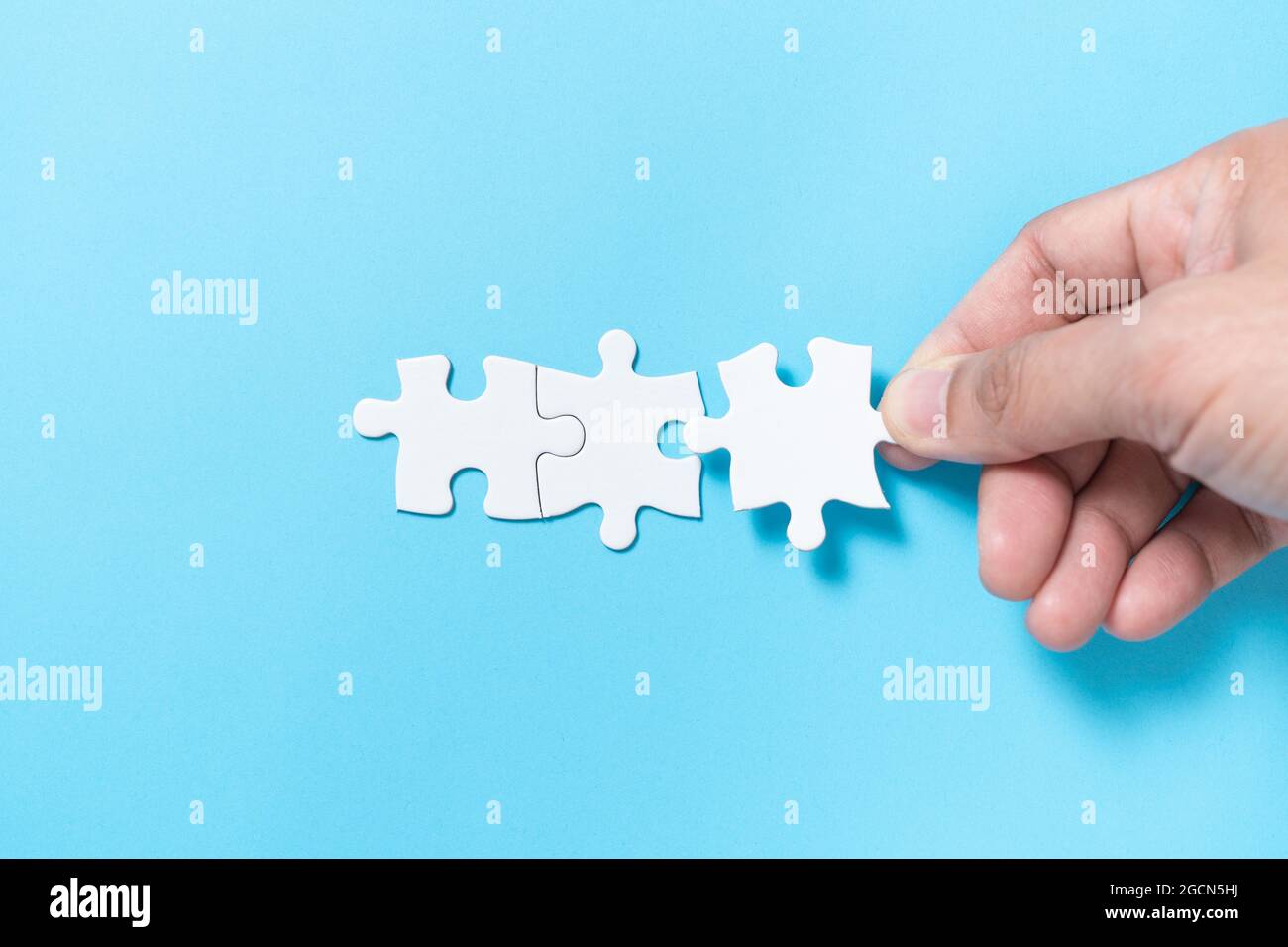 Business merging concept using white jigsaw puzzle Stock Photo - Alamy