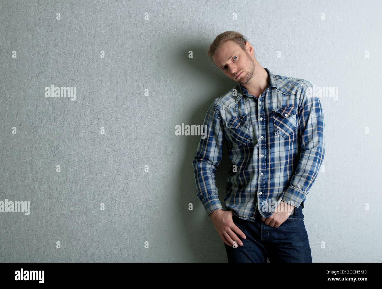 Fashion young model poses over wall with shadow Stock Photo - Alamy
