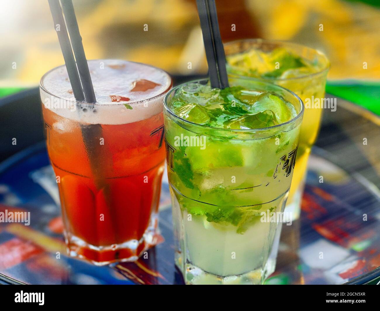 Red and green glasses of aperitif. Appetizers on a gtray on the beach ...