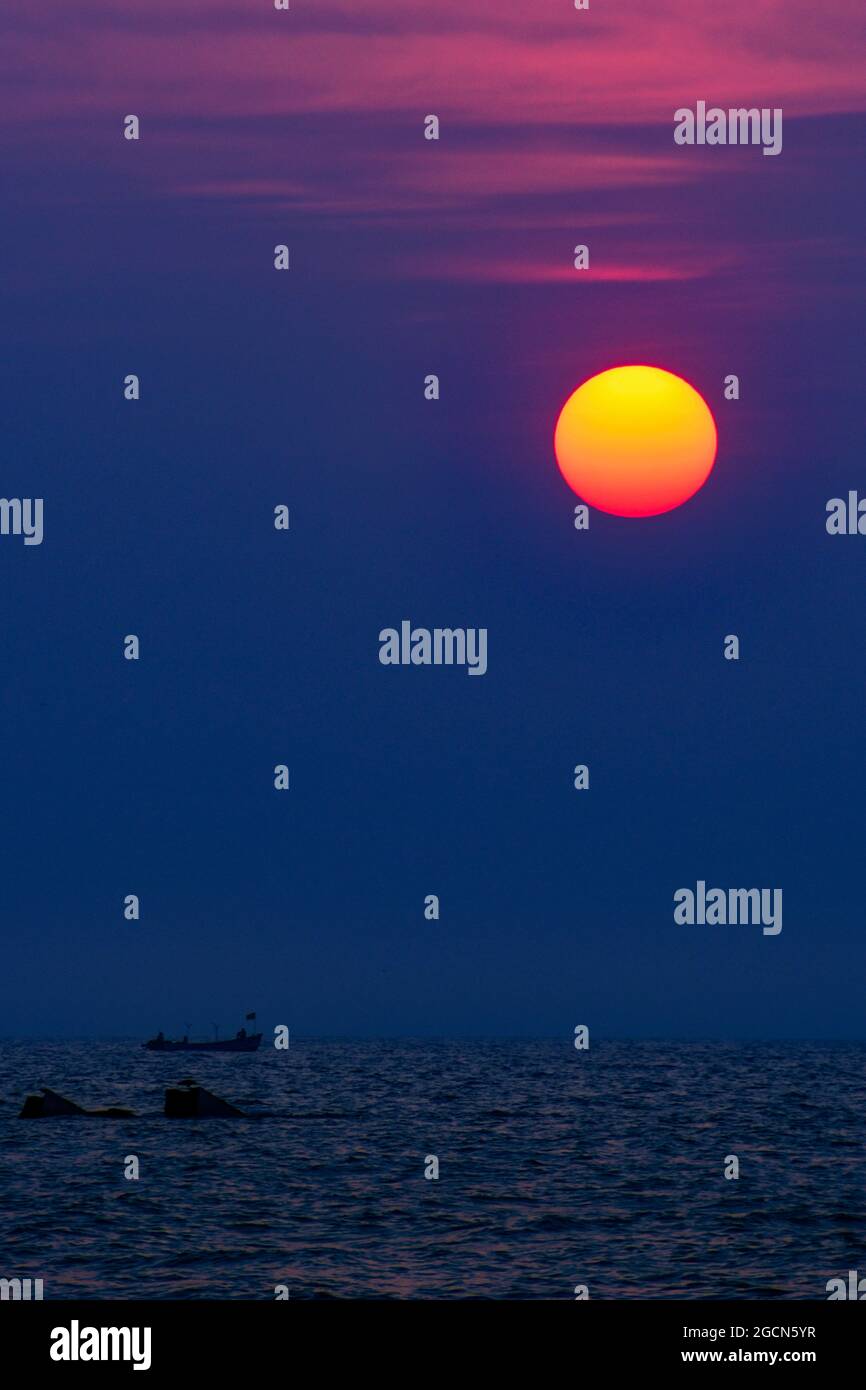 Vertical shot of the beautiful sun setting over the endless ocea Stock ...