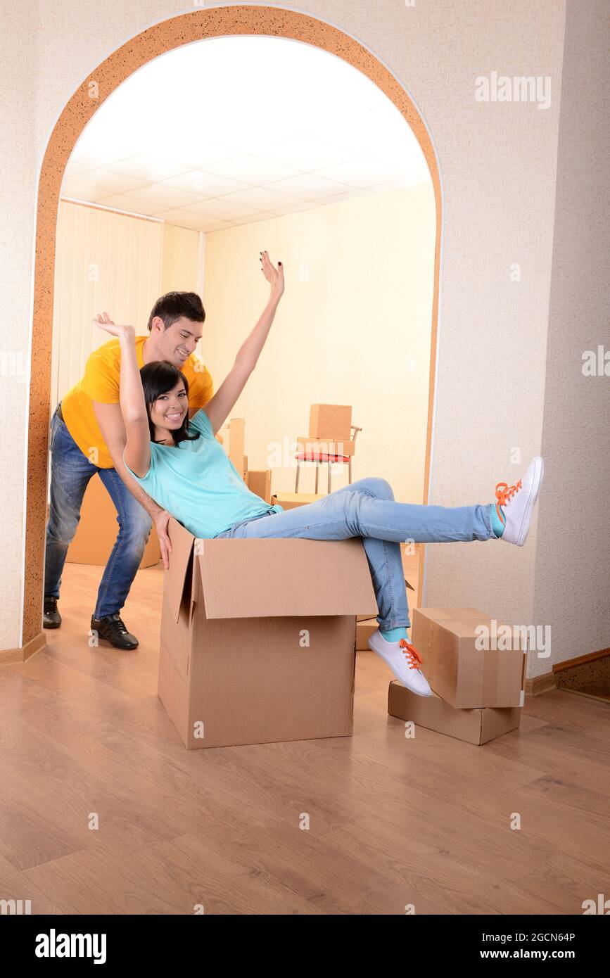 Young couple fooling around in new house on room background Stock Photo ...