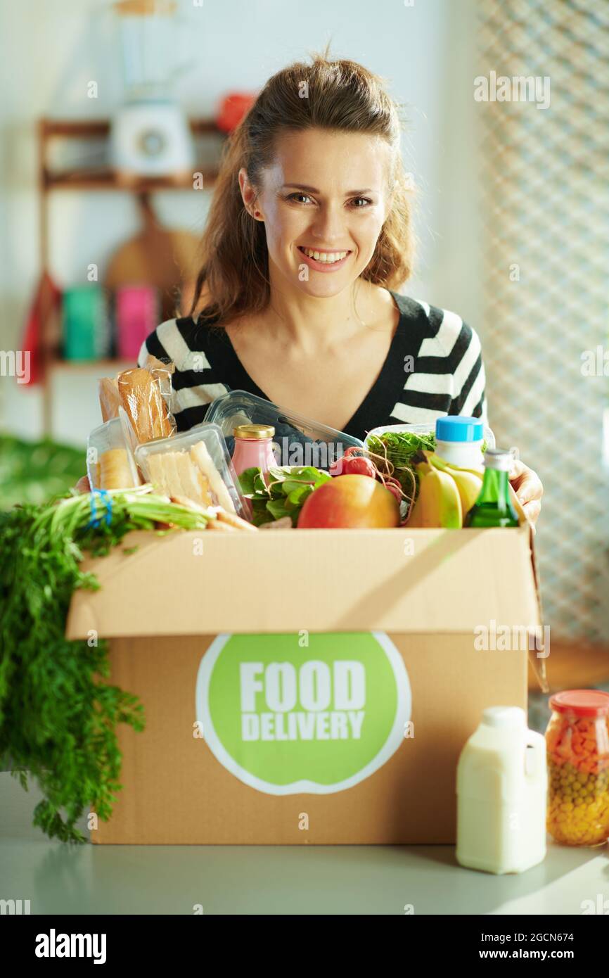 Food delivery. happy modern woman with food box in the kitchen Stock ...