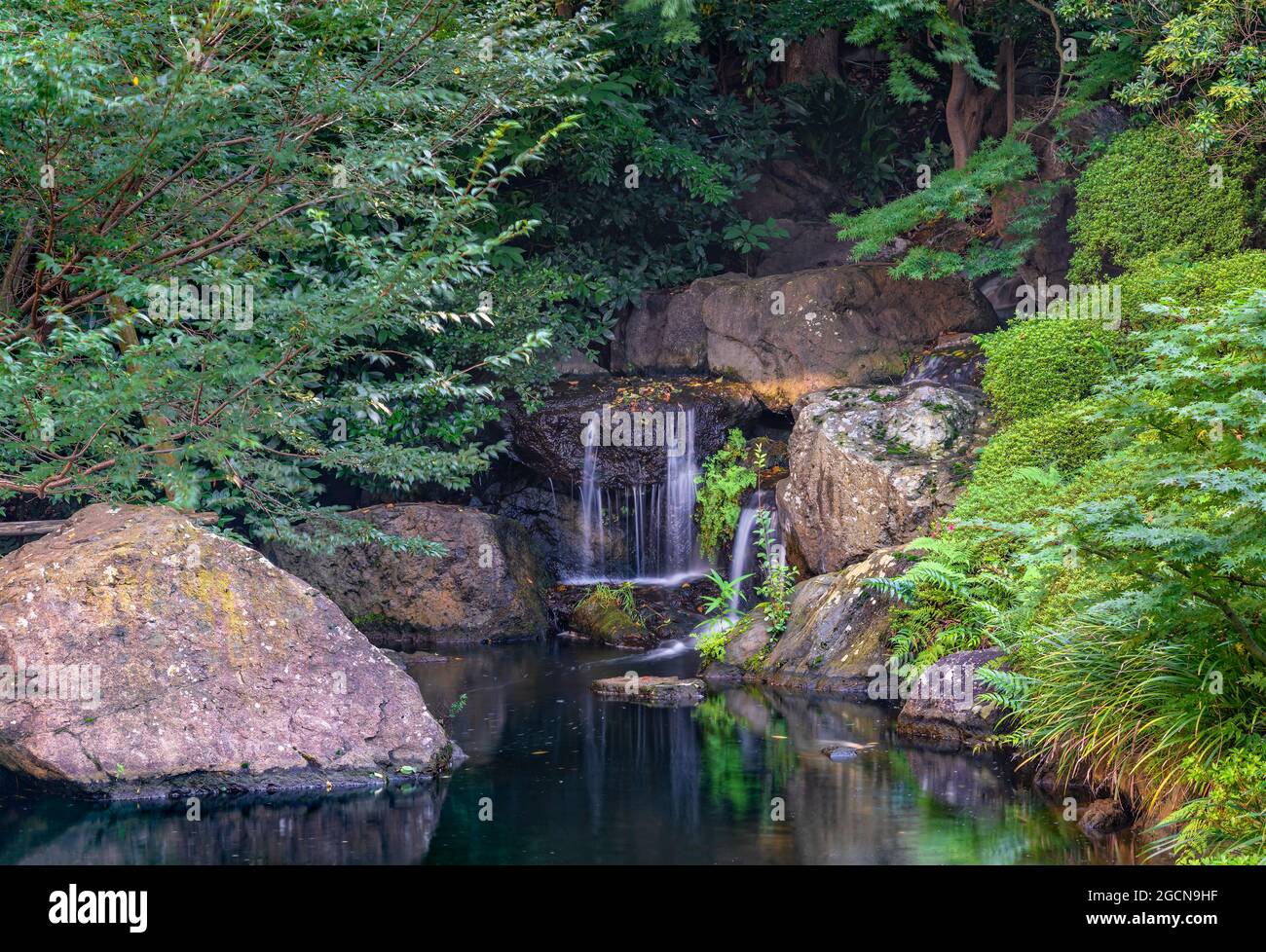 tokyo, japan - july 25 2021: Closeup long exposure of a small waterfall ...