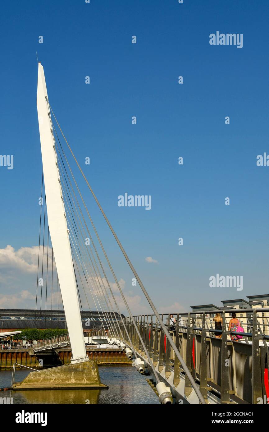 SWANSEA, WALES - JULY 2018: People walking across the Sail Bridge over ...