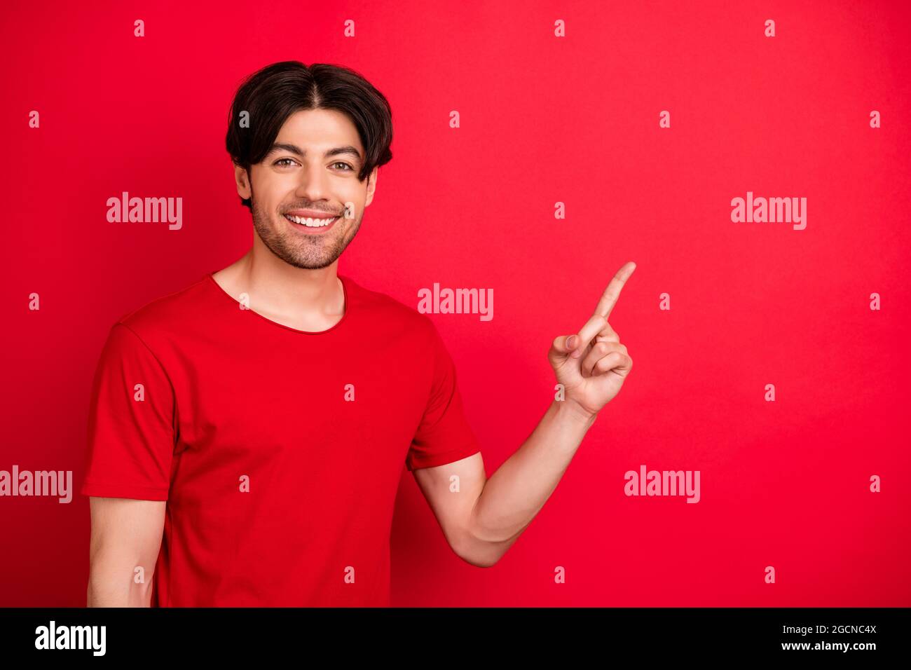 Photo of positive cheerful guy indicate forefinger empty space wear red ...
