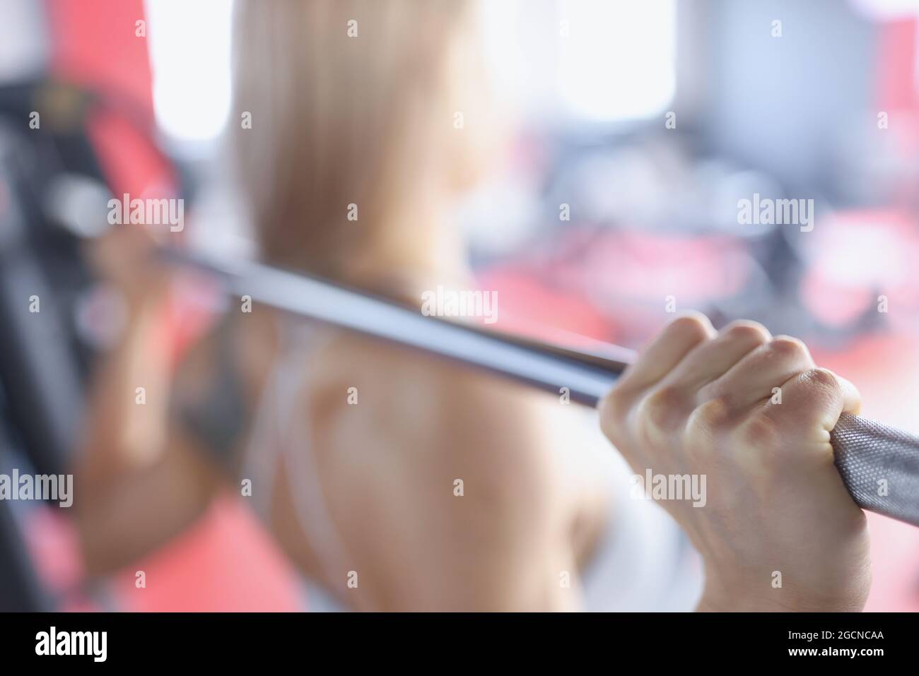 Back view of woman doing exercises with barbell Stock Photo - Alamy
