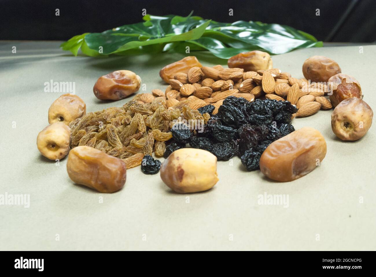 mix dry fruits nuts around dates isolated almonds black and brown ...