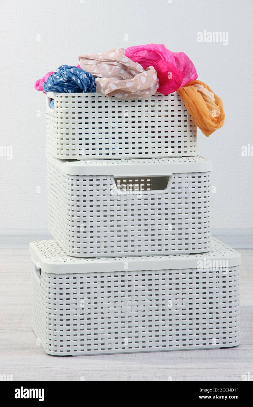 Plastic baskets with things in floor on room background Stock Photo - Alamy