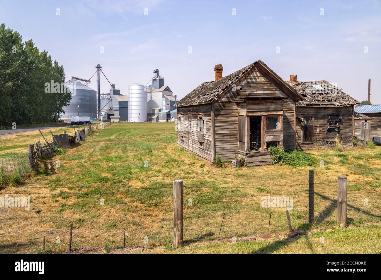 abandoned wooden house in front of modern granaries, Uniontown ...