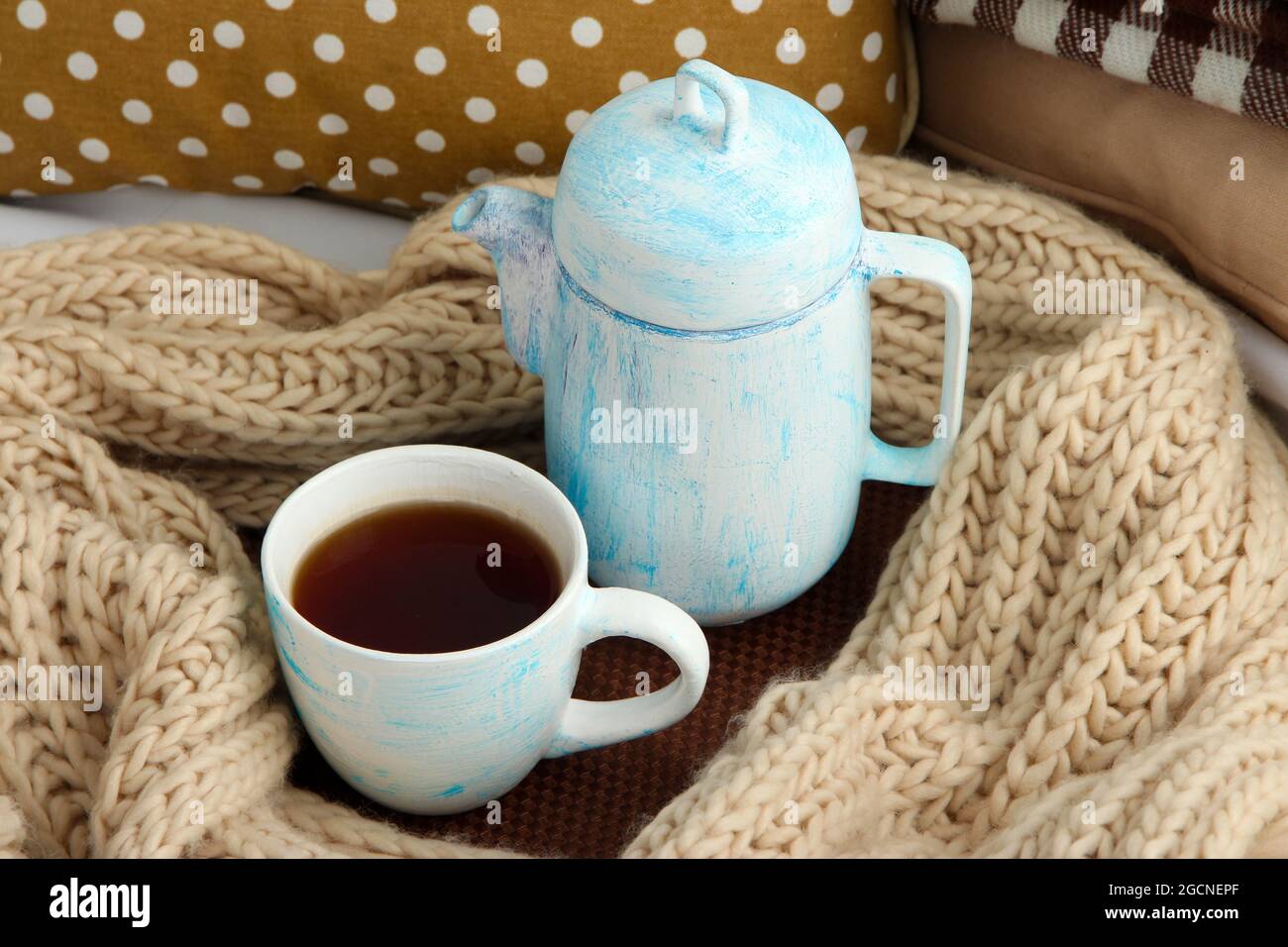 Cup and teapot with scarf on bed close up Stock Photo - Alamy