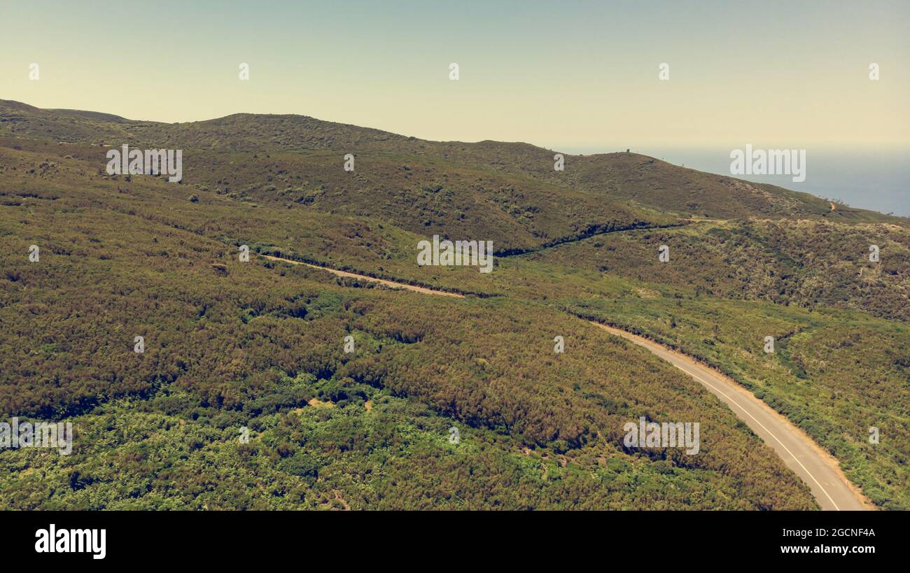 Aerial panorama of road crossing island ridge surrounded with lush ...