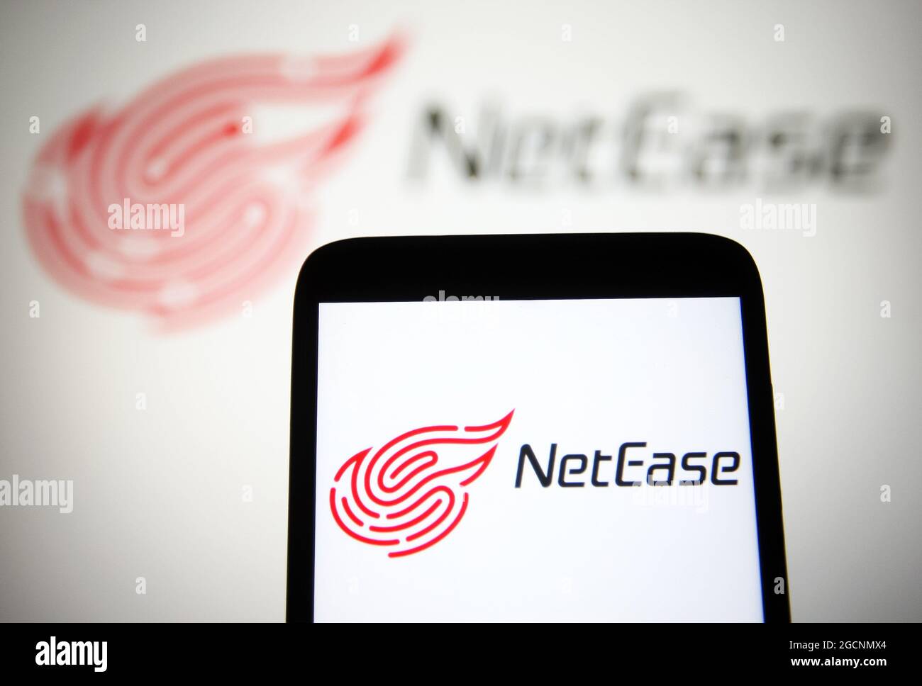 In this photo illustration a NetEase logo is seen on a smartphone and a ...