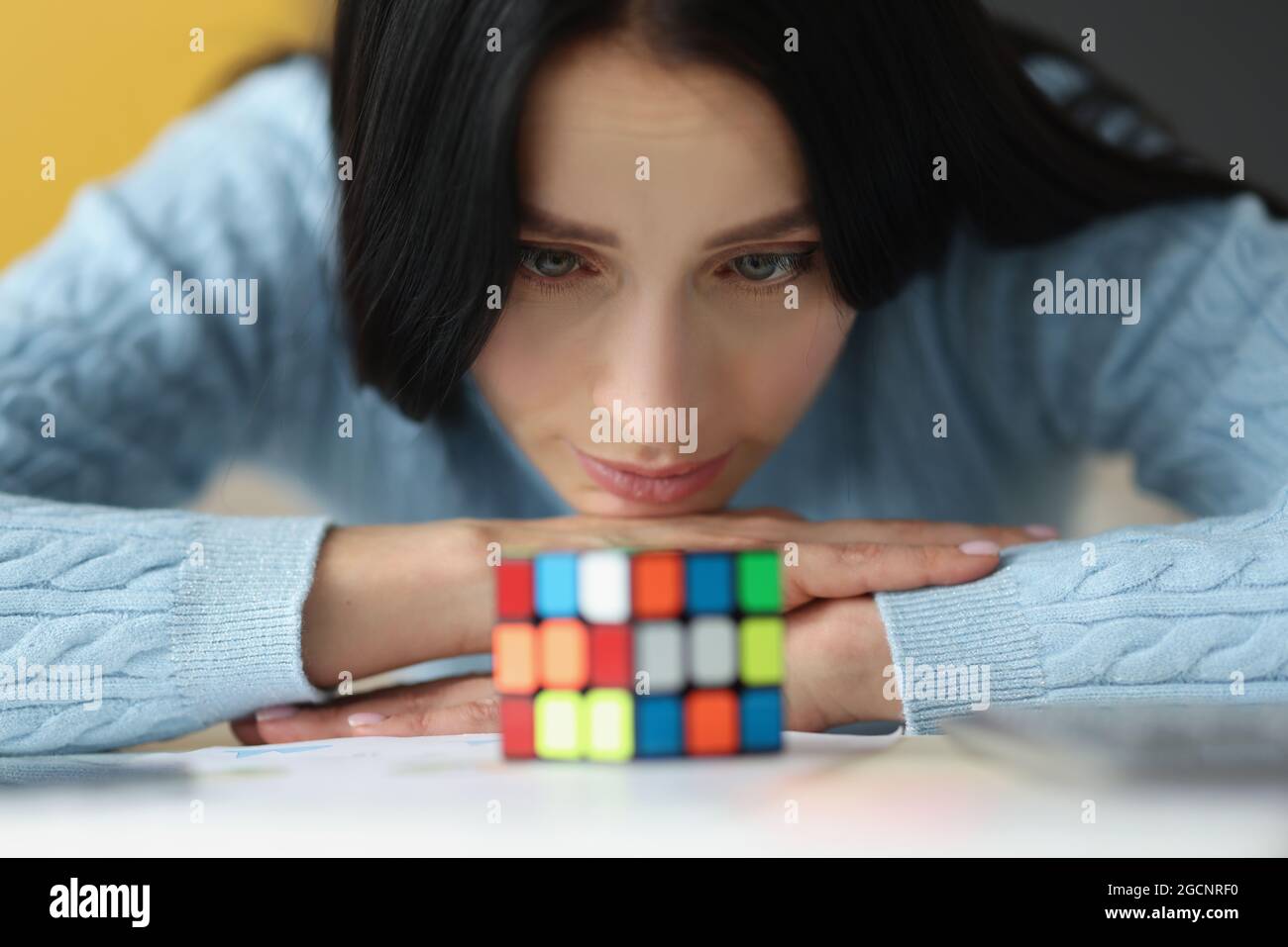 Tired sad woman looks at uncollected Rubik cube Stock Photo - Alamy