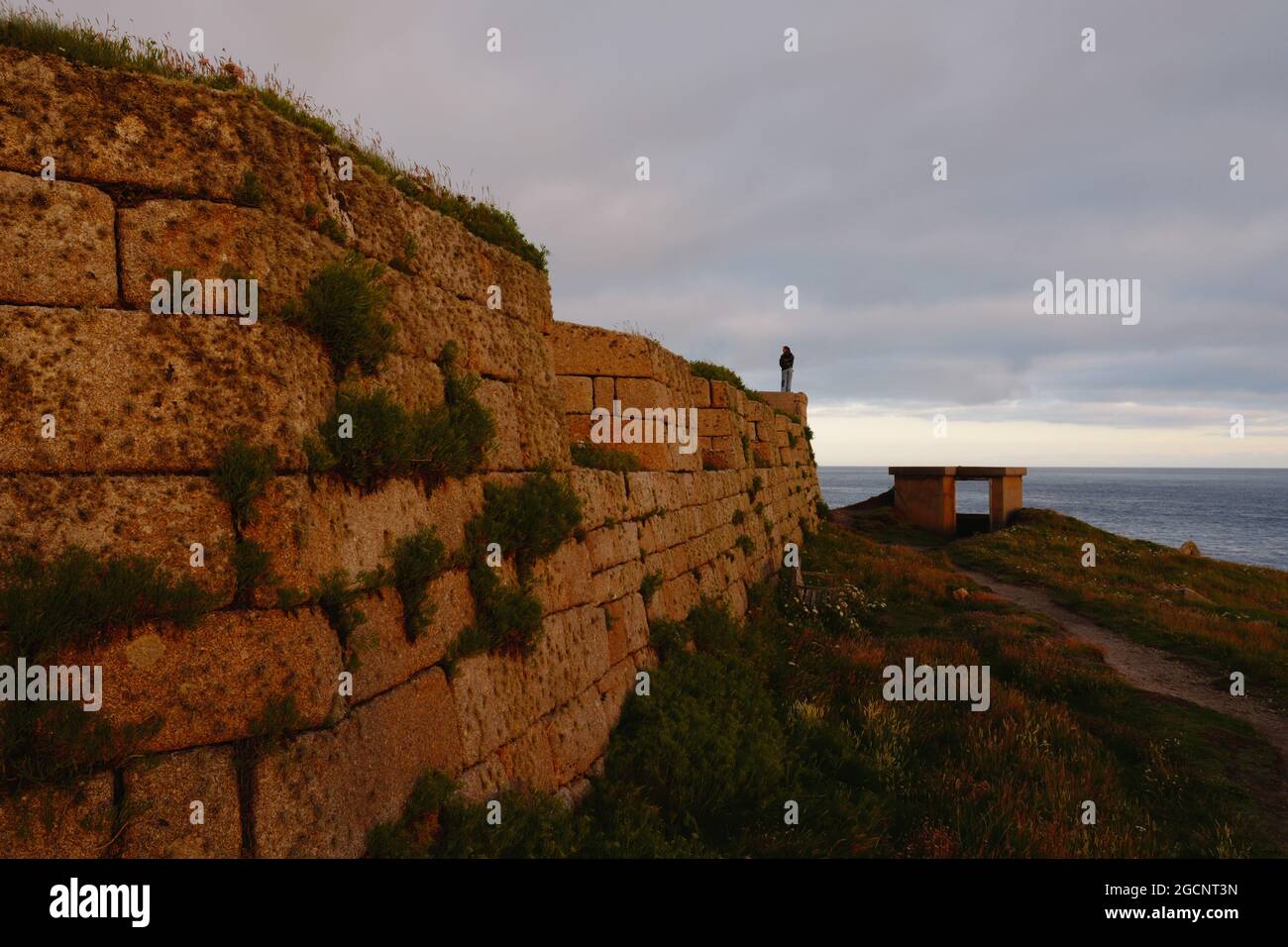 A person walking along the Garrison Walls at sunset, St Mary's island ...