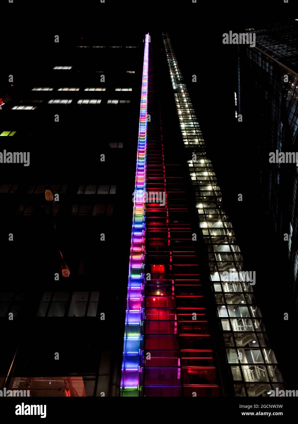 Vertical low angle shot of the colorful lights on a tall skyscraper ...
