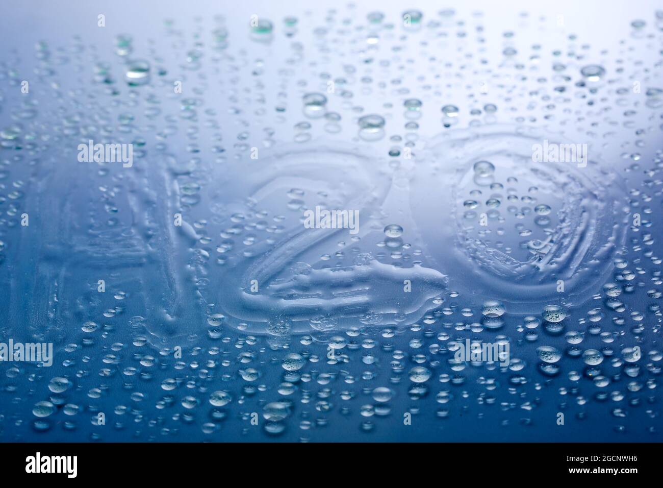 H2O written on water droplets on blue background Stock Photo - Alamy
