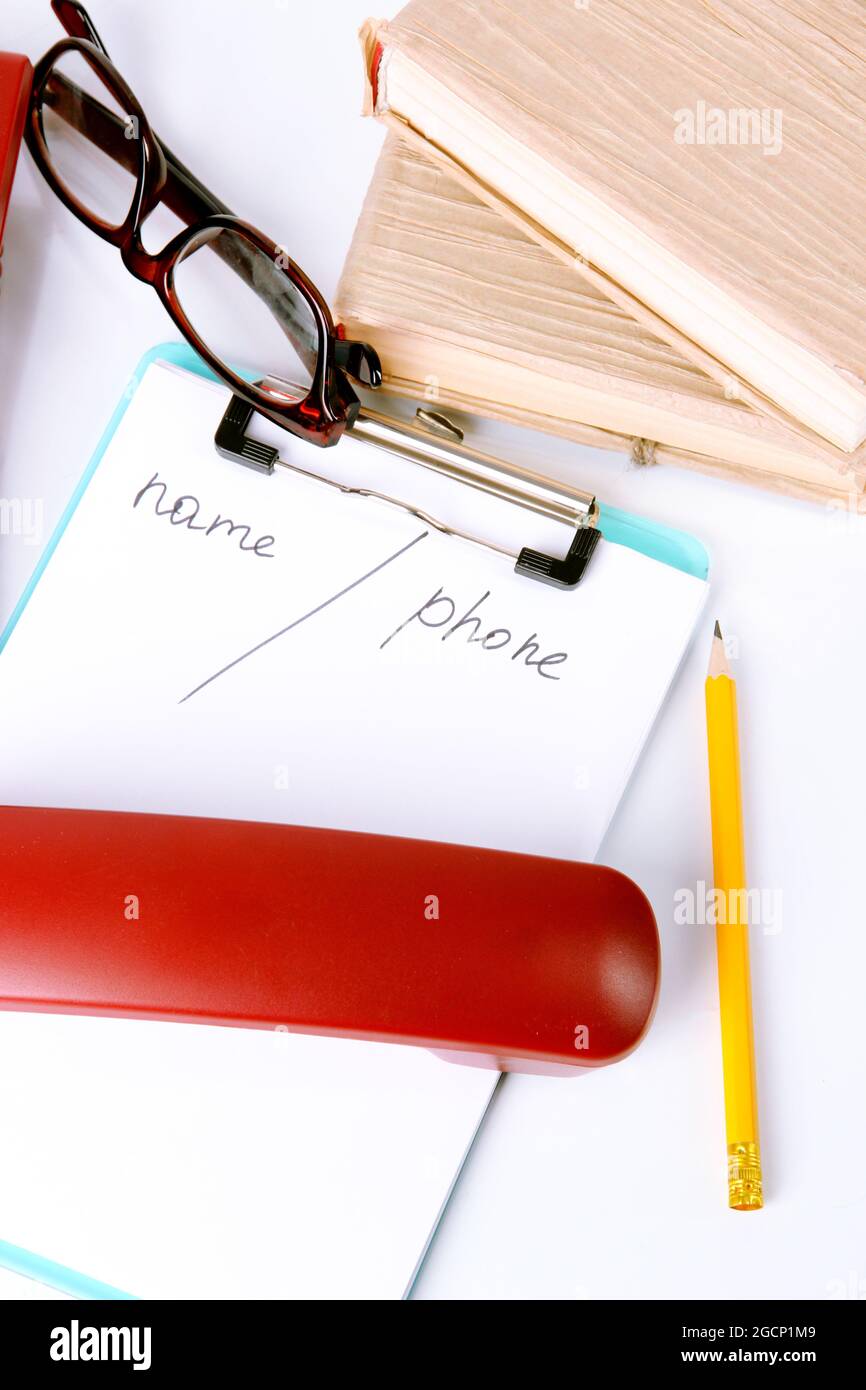 Telephone and notepad and other items, isolated on white Stock Photo ...