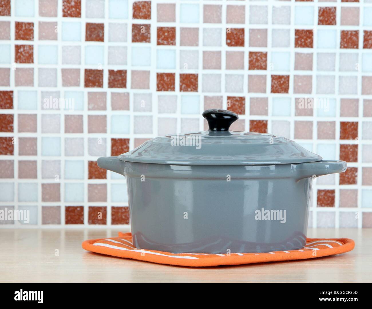 Pan in kitchen on table on mosaic tiles background Stock Photo - Alamy