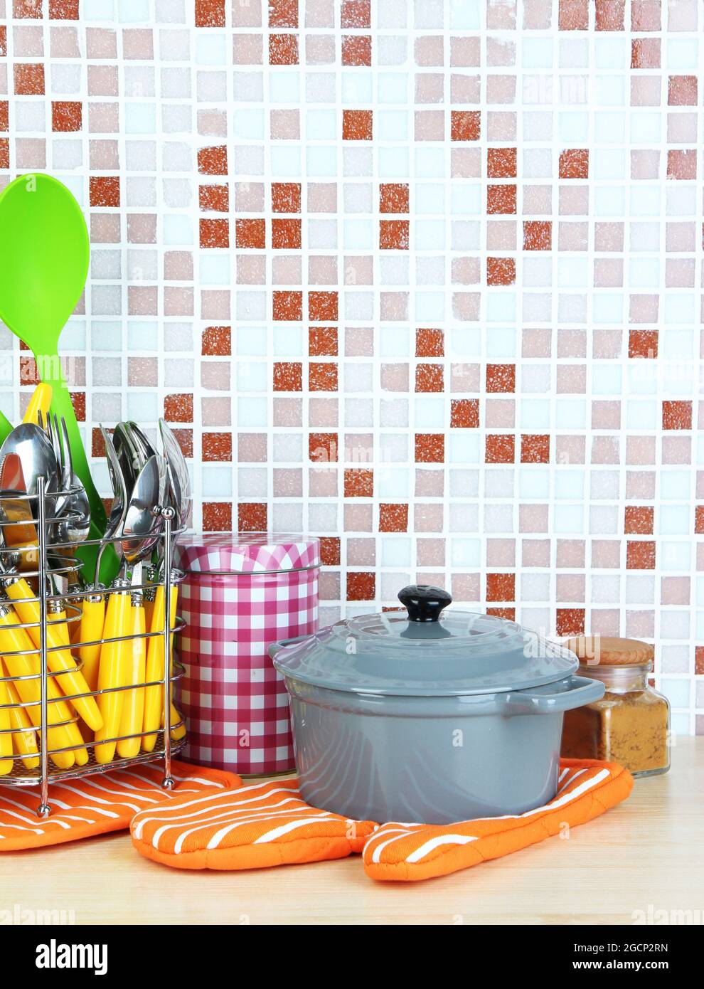 Dishes and cutlery in kitchen on table on mosaic tiles background Stock ...