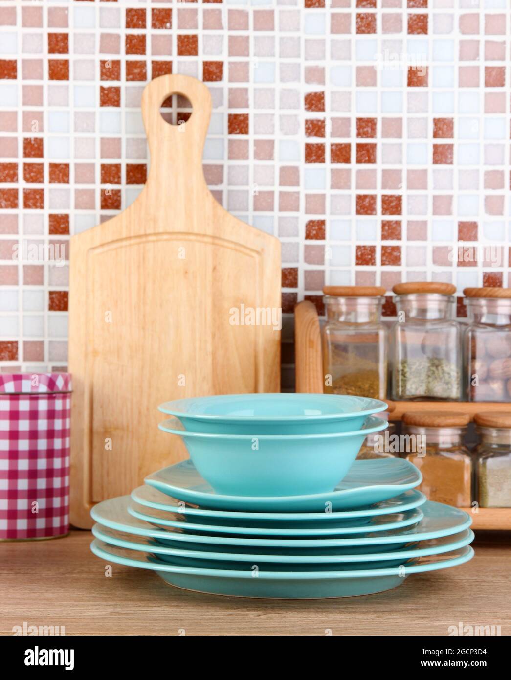 Plates in kitchen on table on mosaic tiles background Stock Photo - Alamy