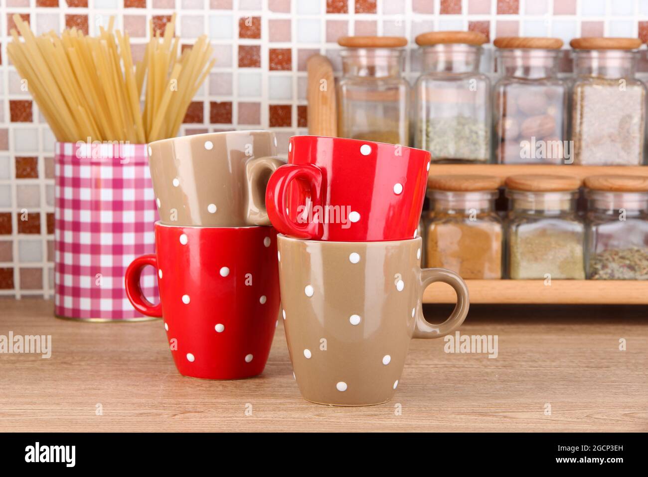 Cups in kitchen on table on mosaic tiles background Stock Photo - Alamy