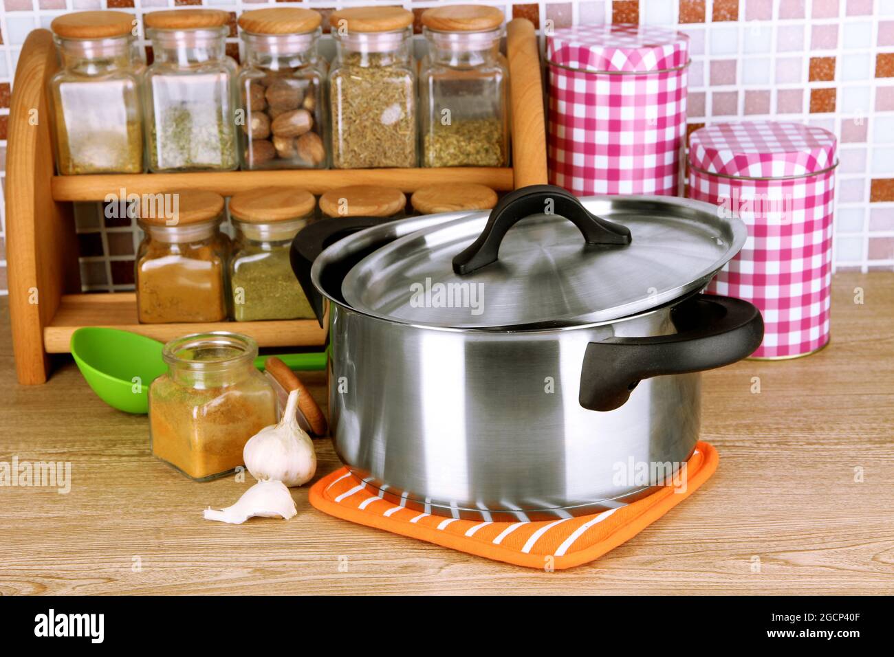 Pot and spices in kitchen on table on mosaic tiles background Stock ...