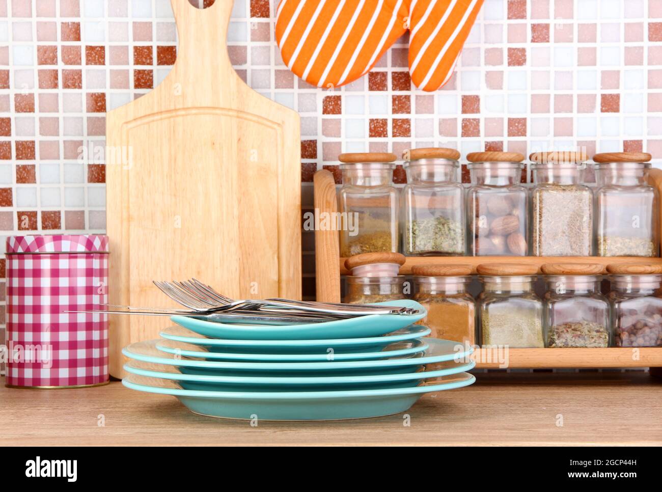Plates in kitchen on table on mosaic tiles background Stock Photo - Alamy