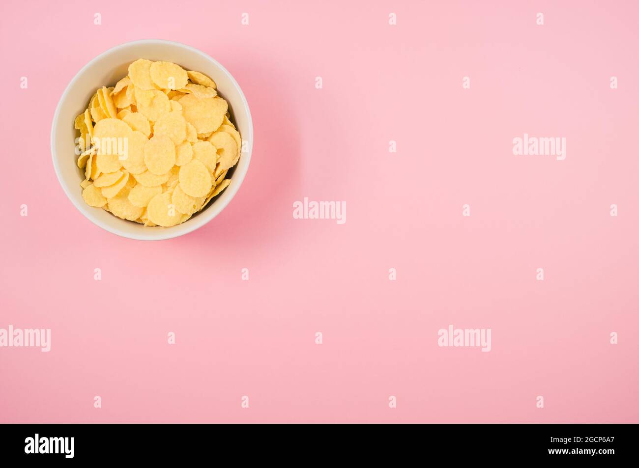 Bowl of cornflakes isolated on a pin background with free space for ...