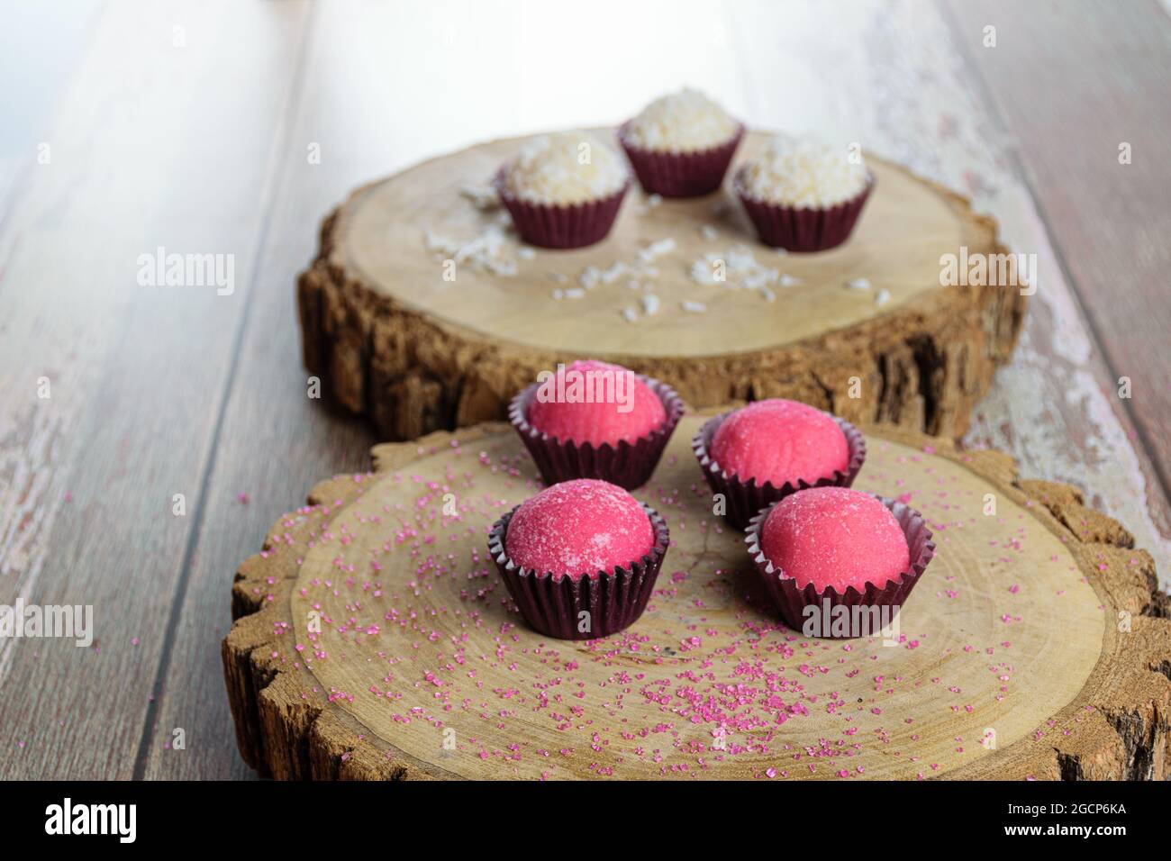 Strawberry Brigadeiros (Bicho de Pe) on tree trunk dishes, sprinkled ...