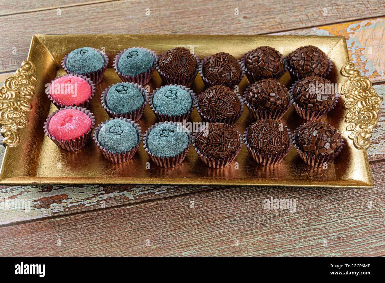 Various types of brigadeiro on a golden tray. Brazilian traditional ...